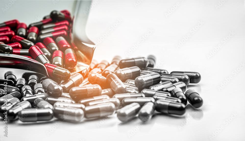 Red and grey capsule pills on stainless steel drug tray and gray ...