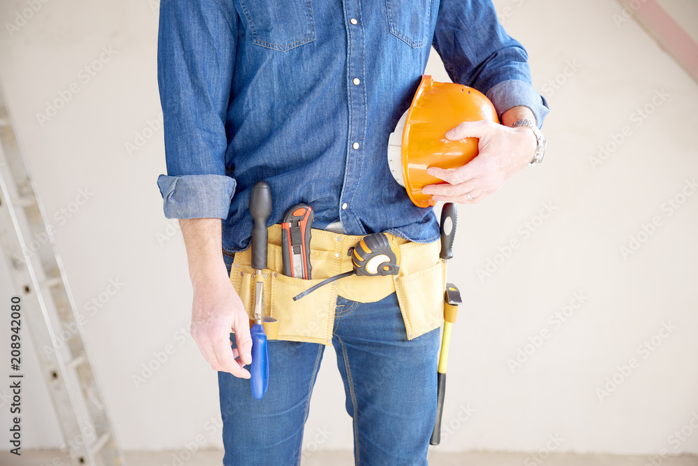Handyman with tool belt and safety helmet Stock Photo | Adobe Stock