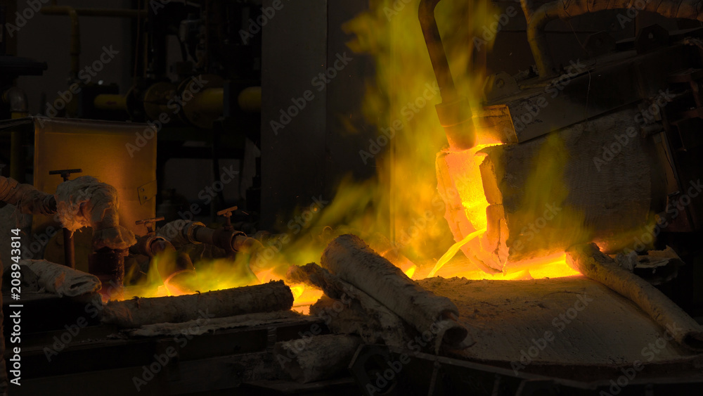 Hot steel pouring at steel plant. In the frame, molten metal is poured ...