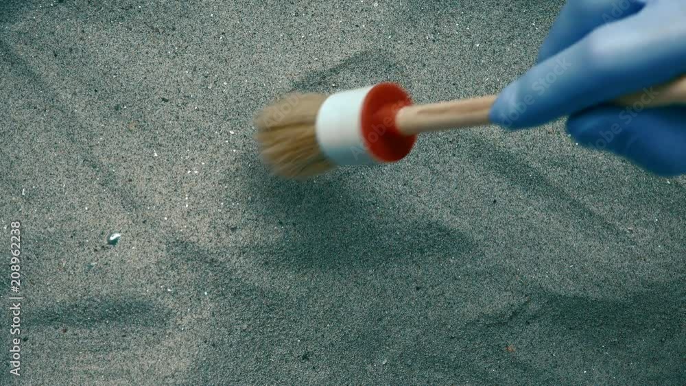 Discovering Justice figure buried in sand during police forensic ...