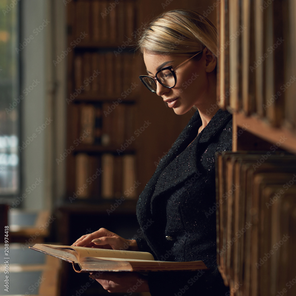 Gorgeous blonde woman wearing black tweed suit and glasses standing ...