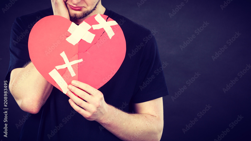 Very sad man holding broken heart Stock Photo | Adobe Stock