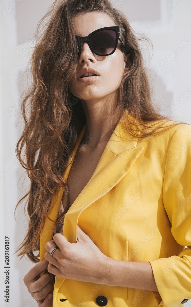 Young Female Fashion Model In Abstract White Space With Yellow Outfit