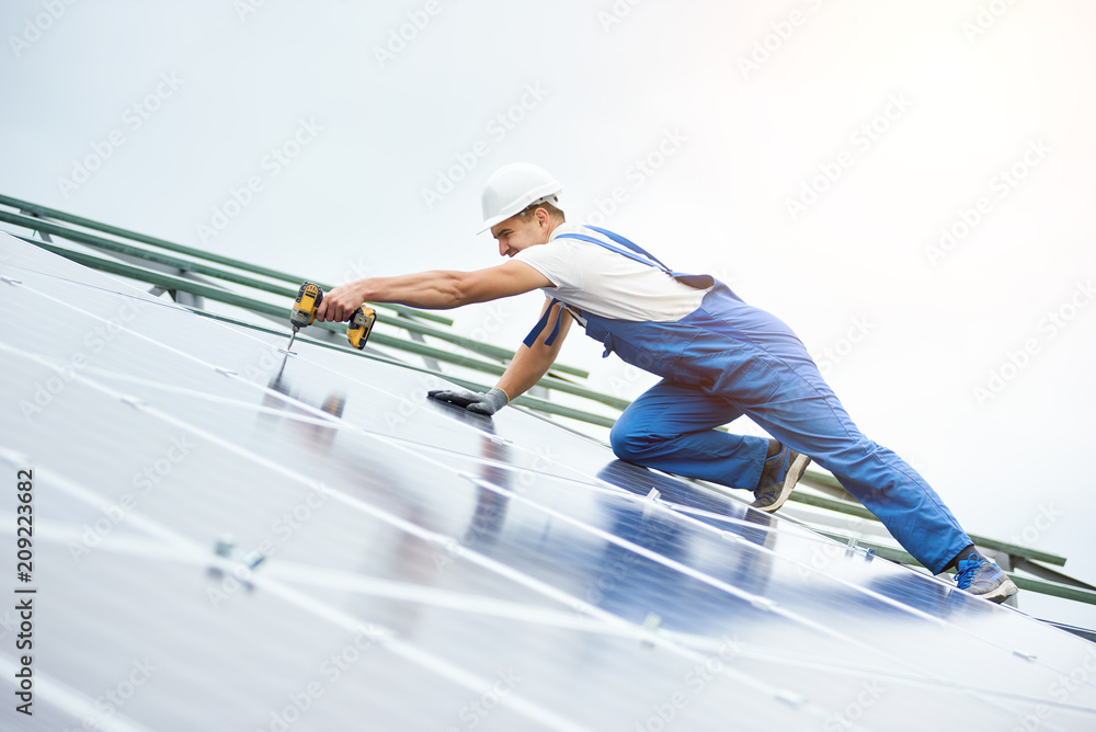 Construction worker connects photo voltaic panel to solar system using ...