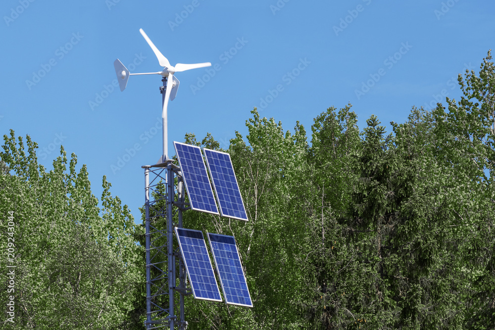Wind generator and solar panels in the forest. Concept: renewable ...