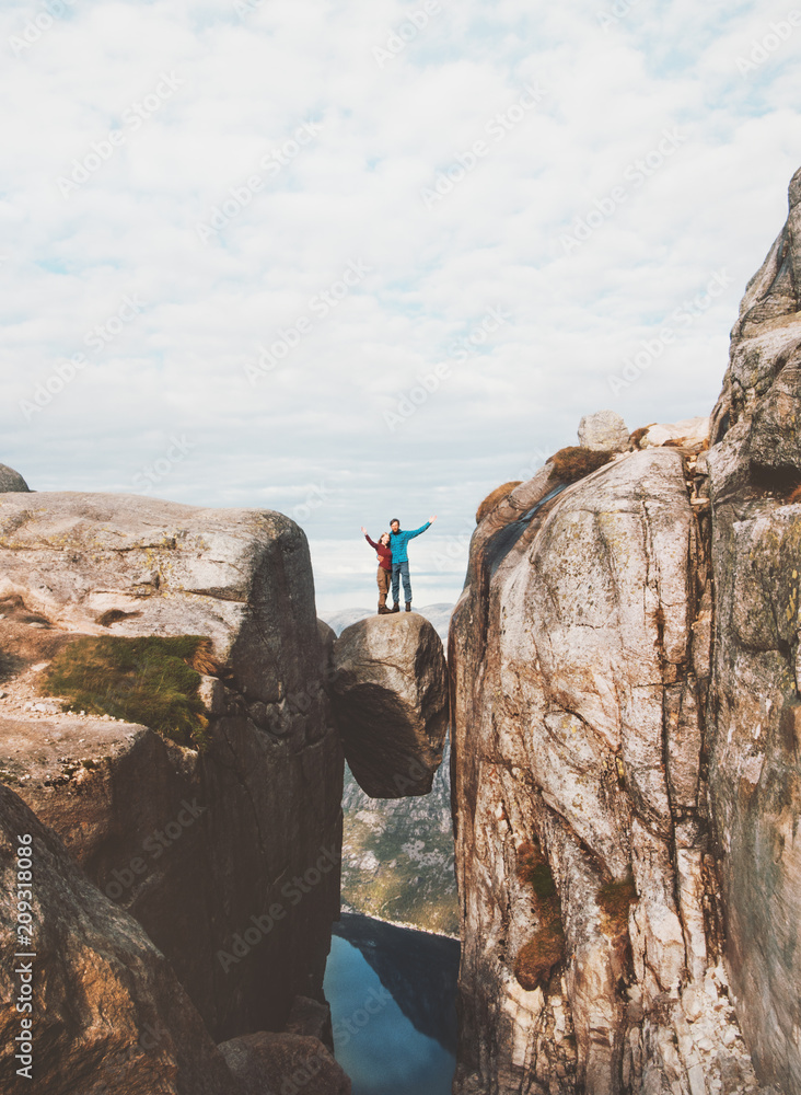 Couple standing on Kjeragbolten Traveling in Norway extreme vacations ...