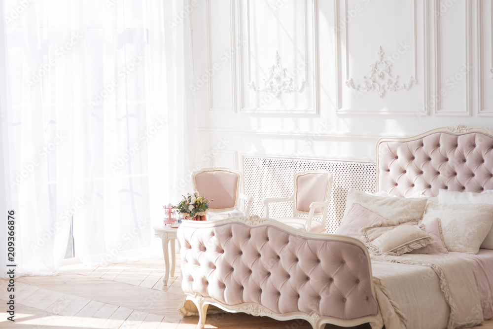 Classic interior bedroom with light pink bed woodn floor two chairs and ...