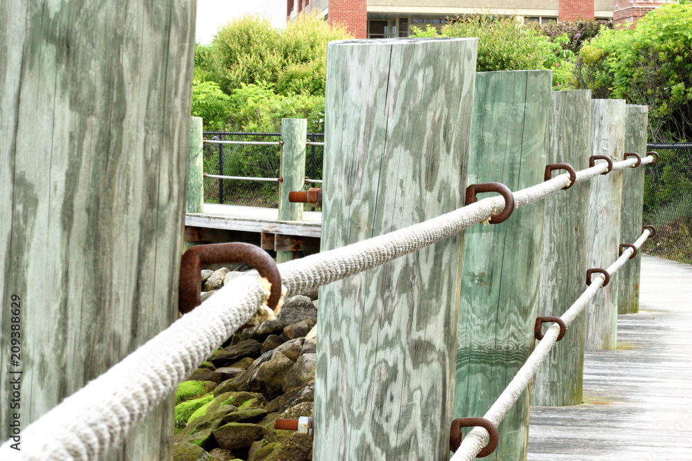 Rope railing on a wooden walkway along the coast of a bay Stock Photo ...