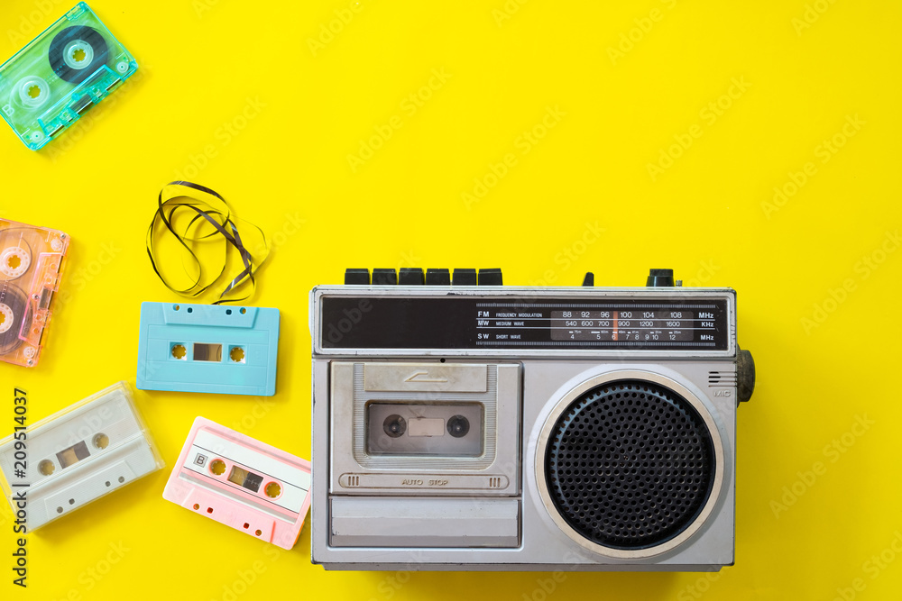 vintage radio and cassette player on yellow background, flat lay, top ...