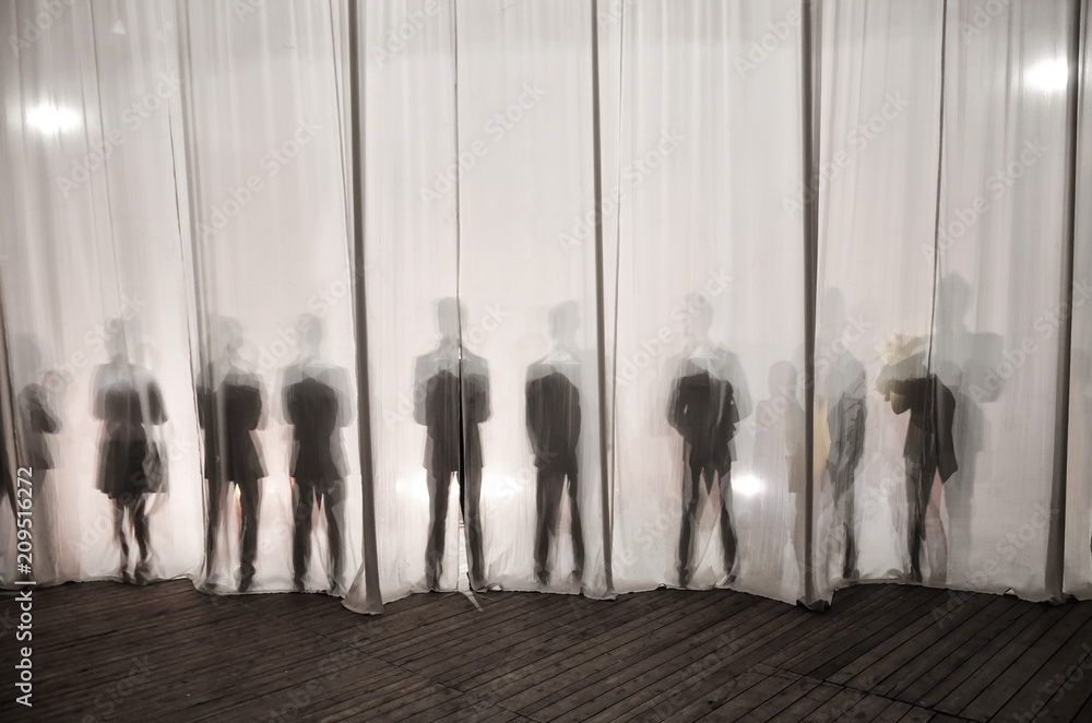 the silhouette of the men behind the curtain in the theater on stage ...