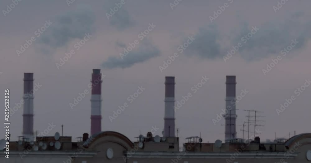 Four tall chimneys with thick smoke rising from two of them. Tiny ...