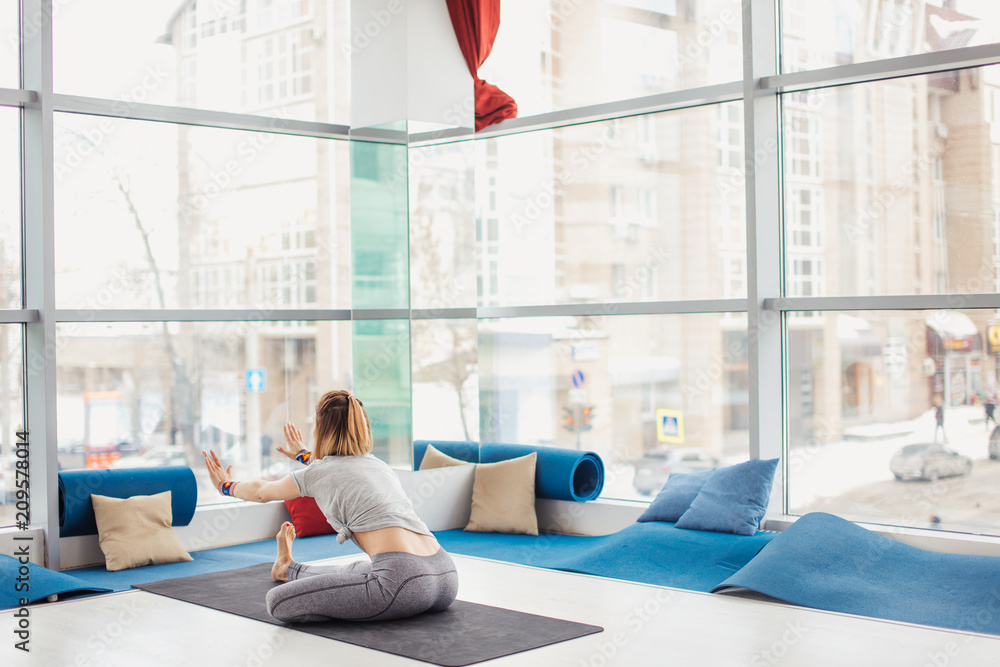 Rear view of training unrecognizable woman in transparent yoga class ...