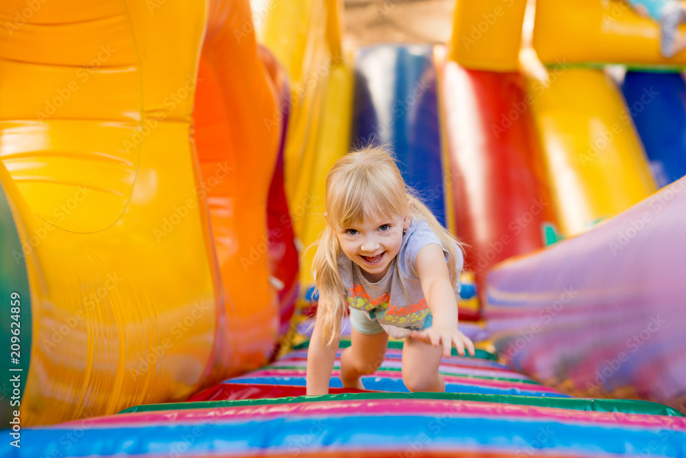 happy excited girl having fun on inflatable attraction playground ...