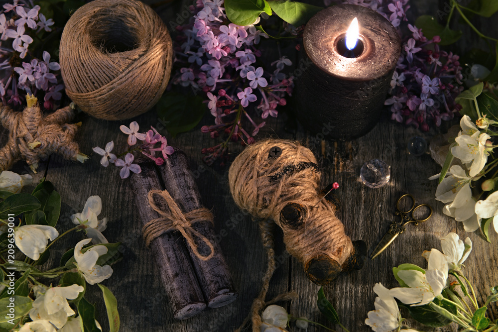 Voodoo magic with doll, black candles, mystic objects and spring ...