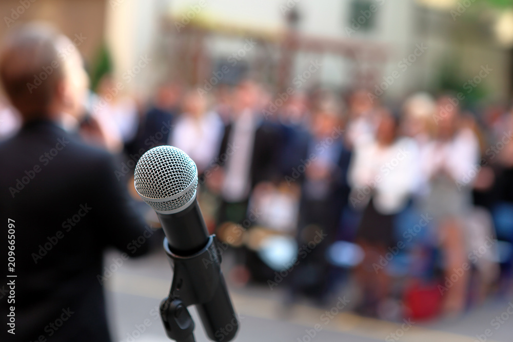 Microphone and stand in front of graduation ceremony audience against a ...