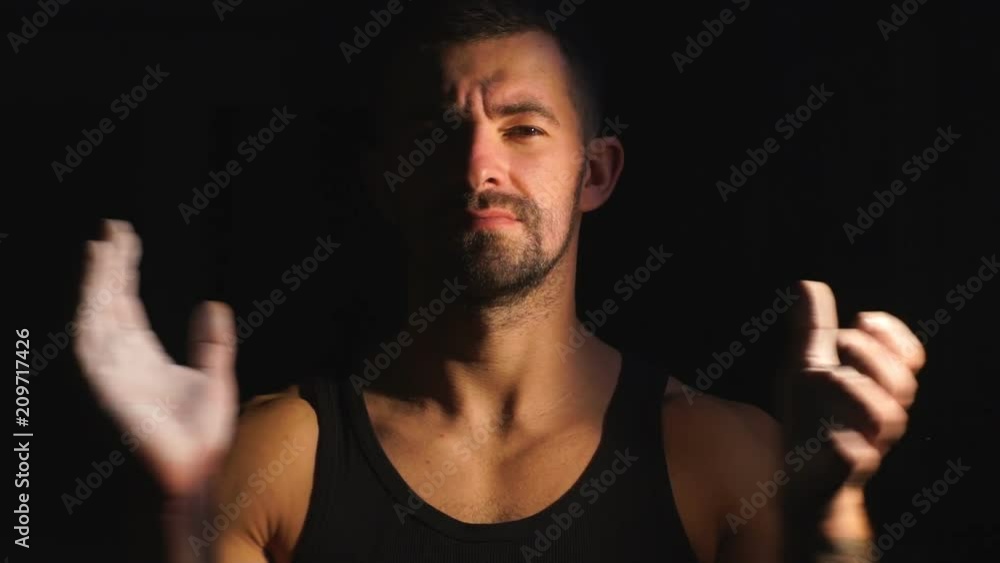 strong muscular bearded bodybuilder clapping hands with chalk powder ...