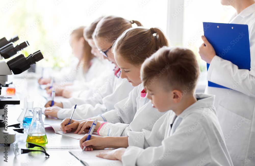 education, science and children concept - teacher and kids studying ...