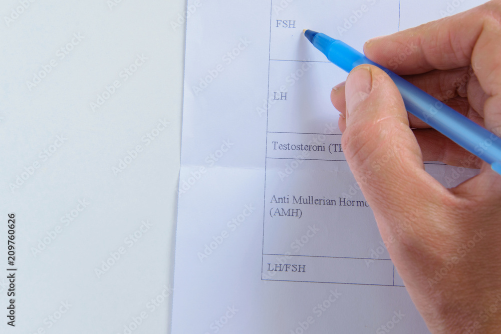 Top view of doctor hand consults blood tests list for female hormones ...