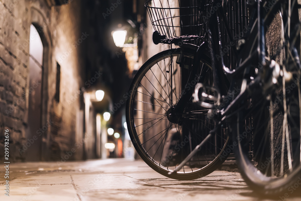 retro bicycle in the night old city on background bokeh light flare in ...