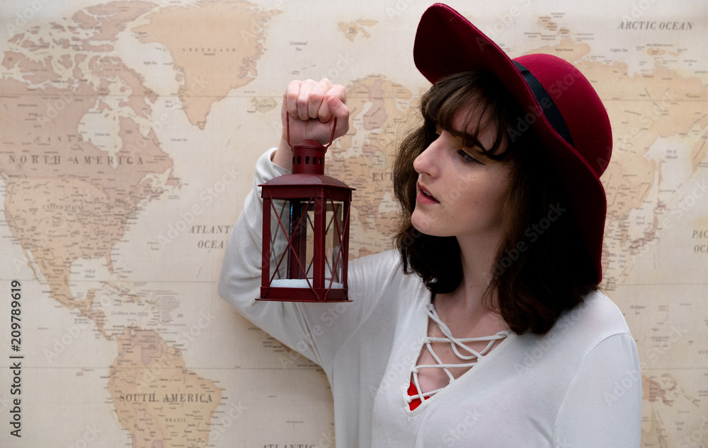 Beautiful young woman poses as explorer with world map Stock Photo ...