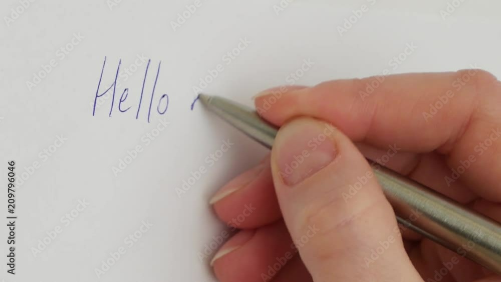 Female hand writes My dear friend on the sheet of white paper. Macro ...