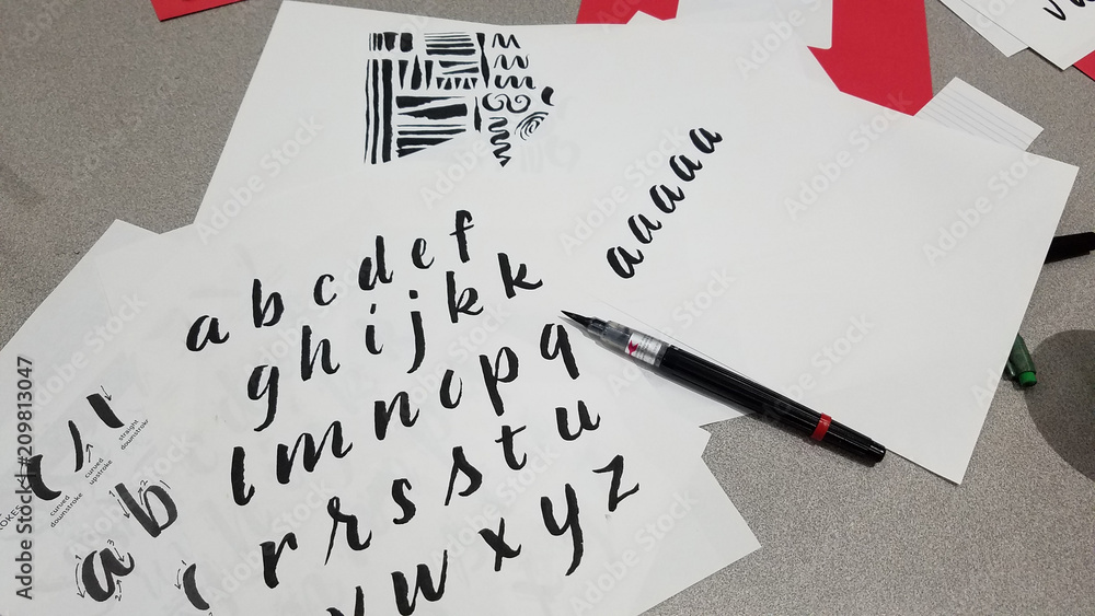 Practicing calligraphy alphabet and strokes in a hand-lettering class ...