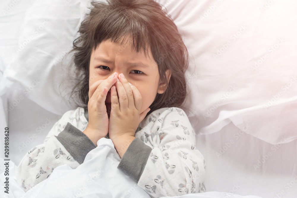 Worried crying child lying on a bed. Stock Photo | Adobe Stock