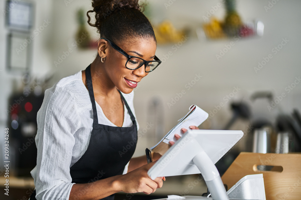 shop assistant placing order from notepad into pos point of sale ...