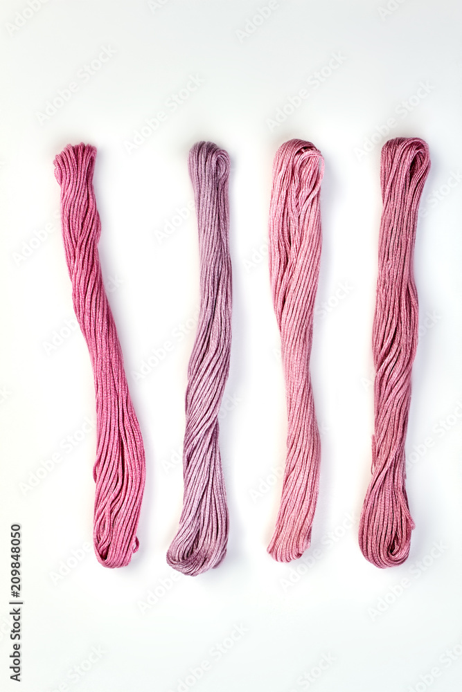 Row of pink color threads, top view. Colorful embroidery threads in ...