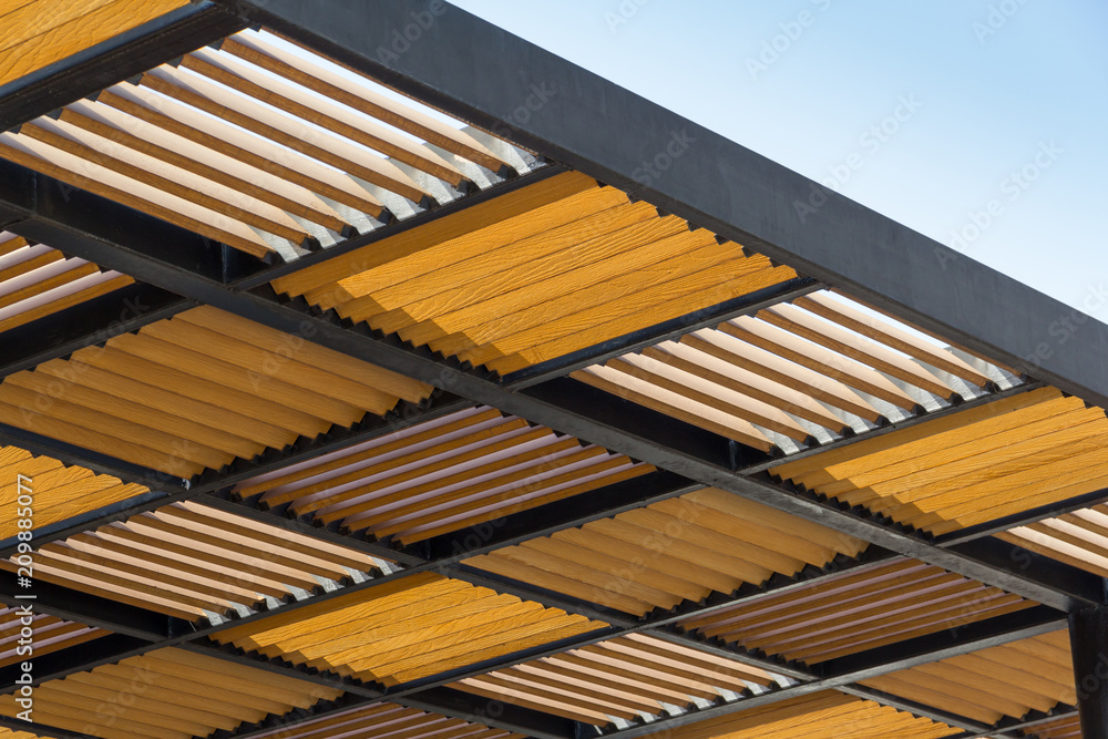 wooden slat shading with steel roof structure against blue sky, timber ...