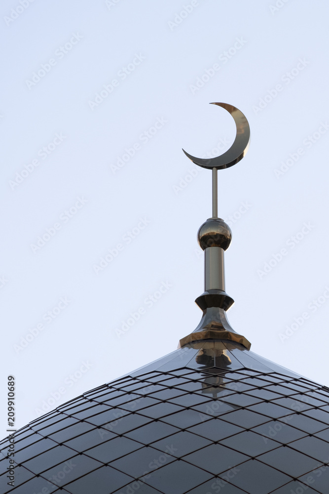 The symbol of Islam is a golden crescent moon on a blue evening or ...