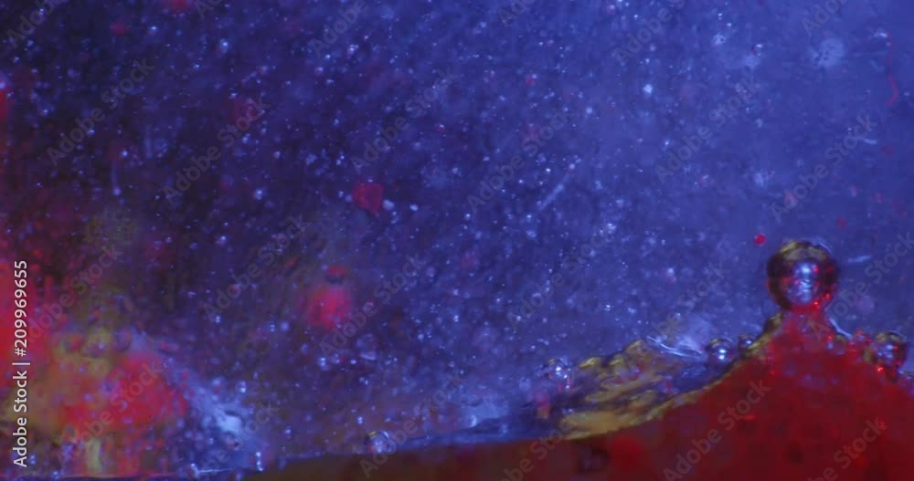 Color drops floating in oil and water over a colorful underground with ...