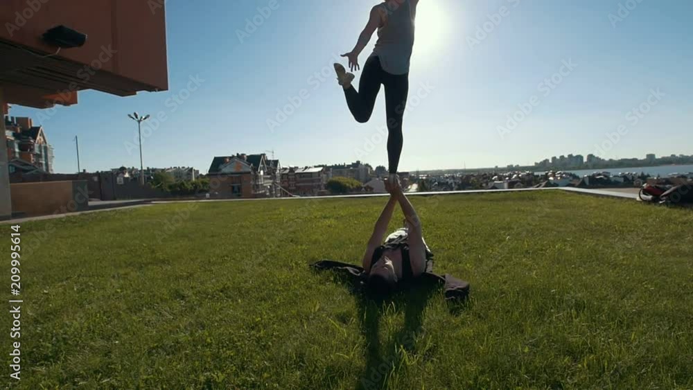 Young sporty couple practicing acrobatics performing front plank bird ...