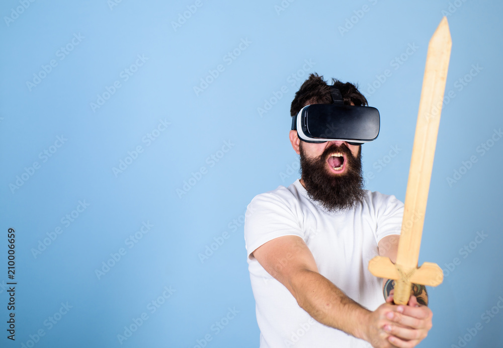 VR gamer concept. Guy with head mounted display and sword play fighting ...