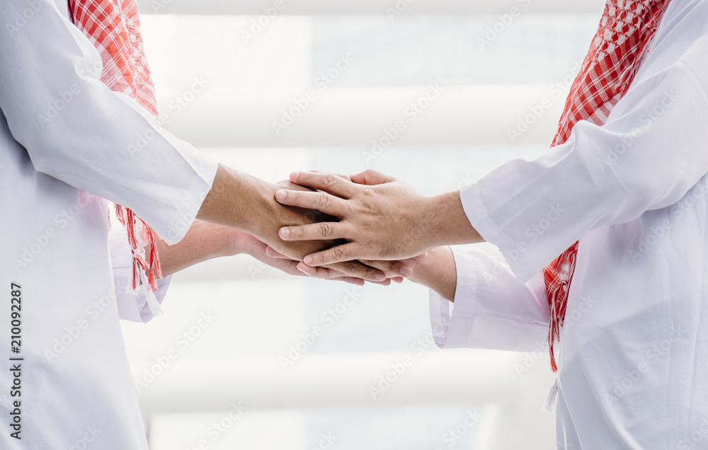 Two Arab shaking hands to greet. Stock Photo | Adobe Stock