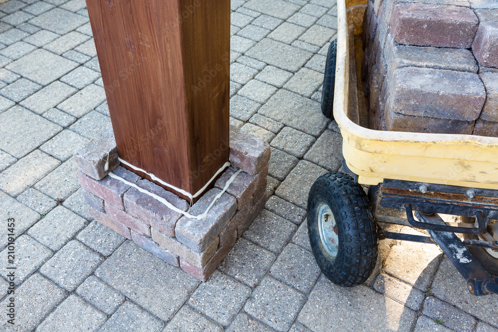 Foto de Installing a new brick pillar around a gazebo leg do Stock ...