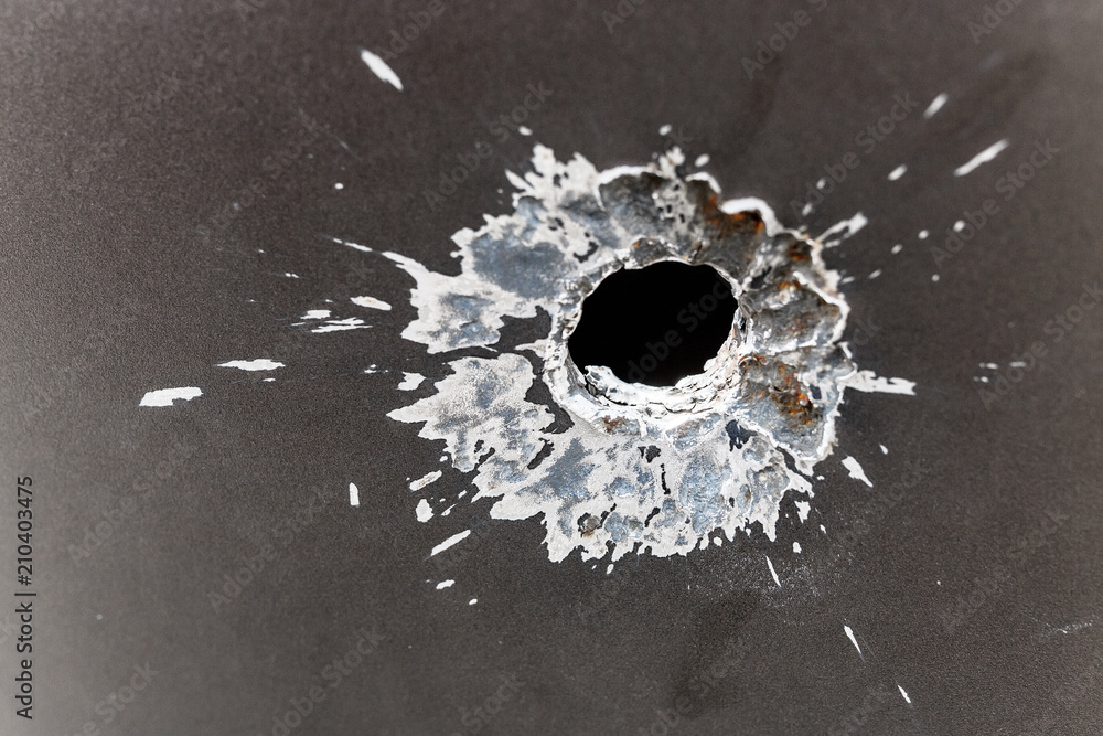 bullet hole in armored metal plate, war conflict and military tragedy ...