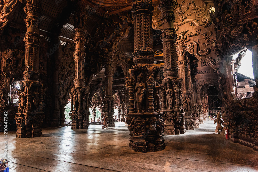 Hall in ancient temple with wooden carved sculptures, dome and columns ...