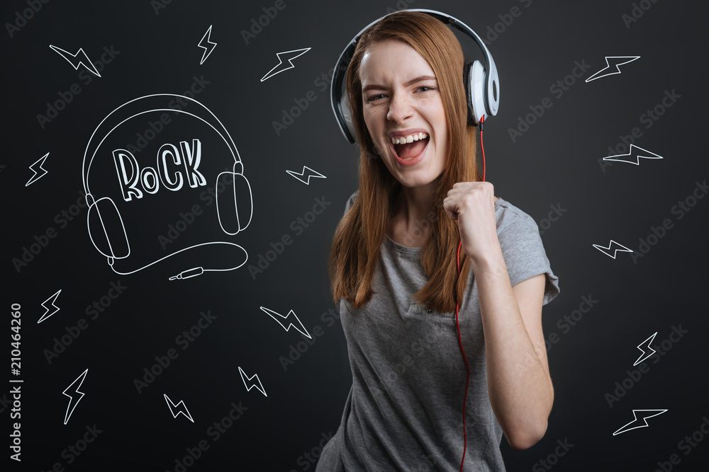 Rock music lover. Positive emotional girl wearing big headphones and ...