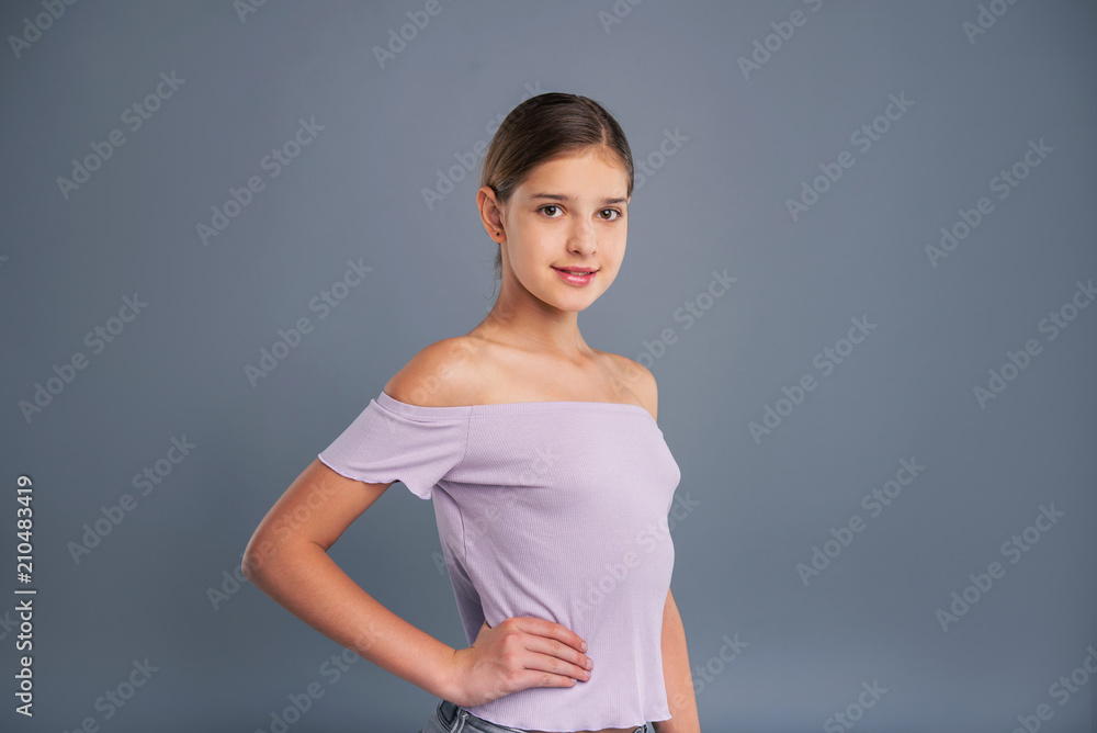 Wannabe model. Charming teenage girl in a lilac strapless top standing ...