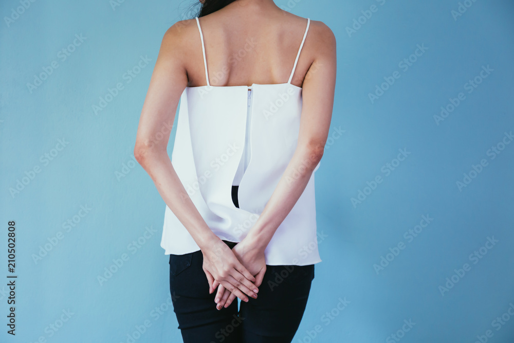 Young woman suffering from buttocks butt pain isolated over blue ...