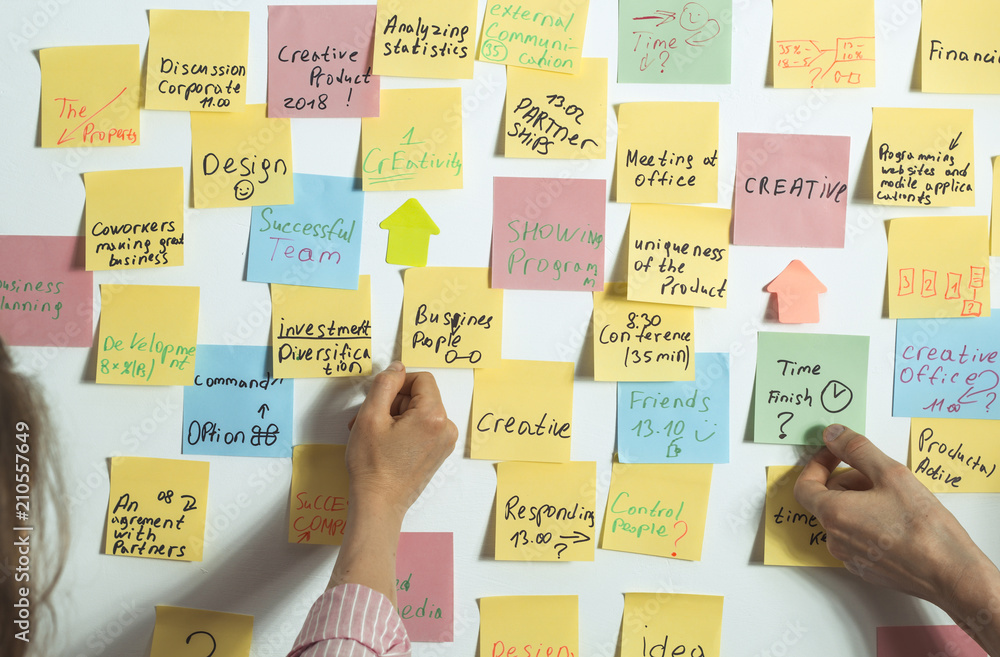 Business people discuss and plan creative work, making notes on paper ...