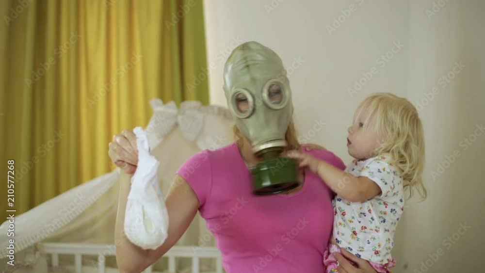 A woman in a gas mask, with a baby, holding a diaper Stock Video ...