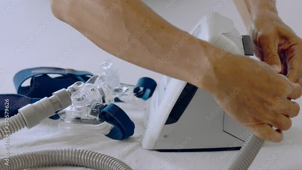Cpap installation . Man hands assembling patient tube to cpap mask and ...