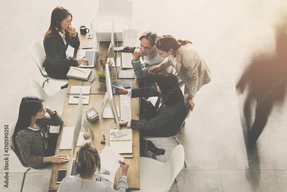 Foto de People working around a table do Stock | Adobe Stock