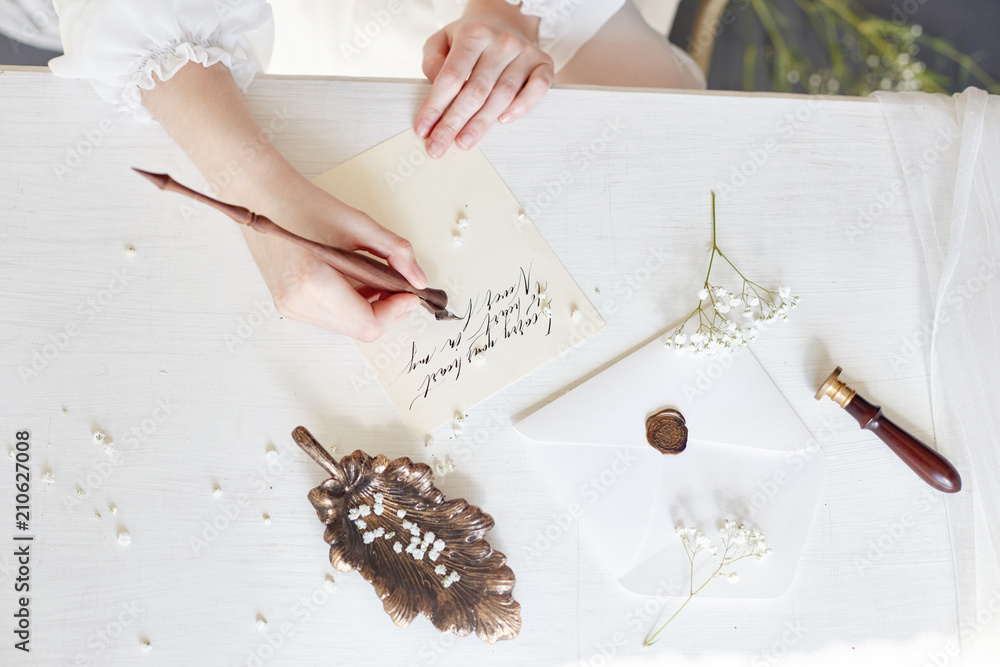 Girl writes a letter to her beloved man, sitting at home at table in a ...