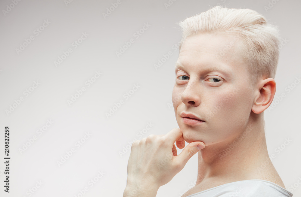Blonde man with masculine unusual appearance looking at camera ...