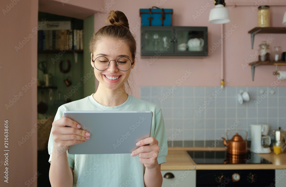 Young woman looking at tablet screen with smile laughing while ...