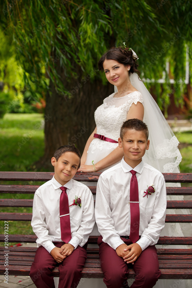 Gorgeous young bride with younger brothers posing at camera, at her ...
