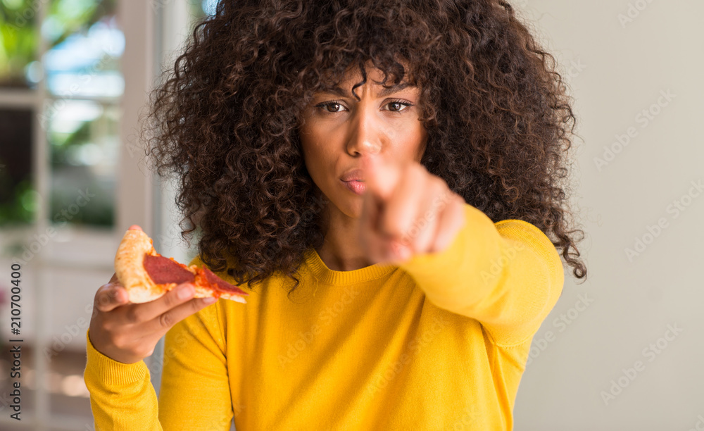 African american woman ready to eat pepperoni pizza slice pointing with ...